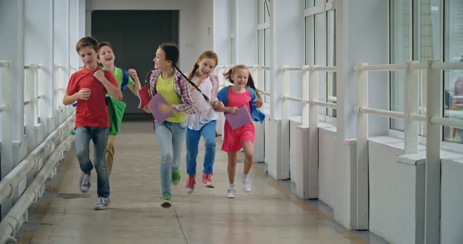 School Friends Approaching Camera While Walking Along Corridor And ...