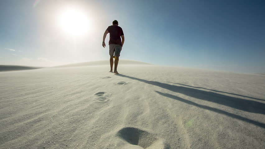 Male Walks On A White Sands Dune. Camera Moves Left As A Male Walks ...