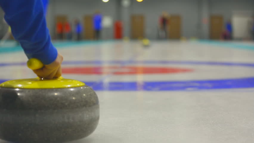 Curling Player Delivering A Stone On A Curling Rink, Sliding Over The ...