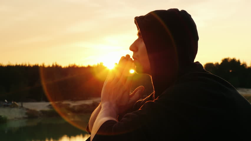 Stock video of young man praying at sunset. he | 18910064 | Shutterstock