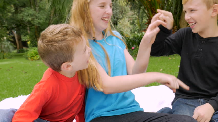 A Group Of Young Kids Playing And Tickling Each Other Outside While ...