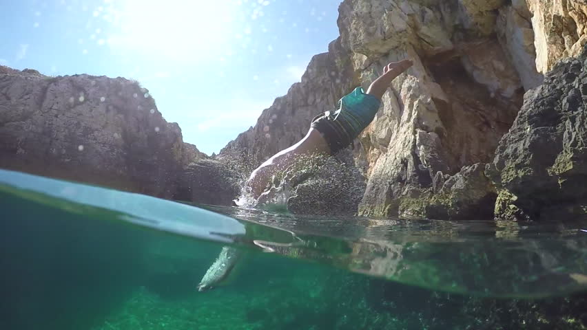 HALF UNDERWATER SLOW MOTION CLOSE UP: Happy Young Man Jumping Headfirst ...