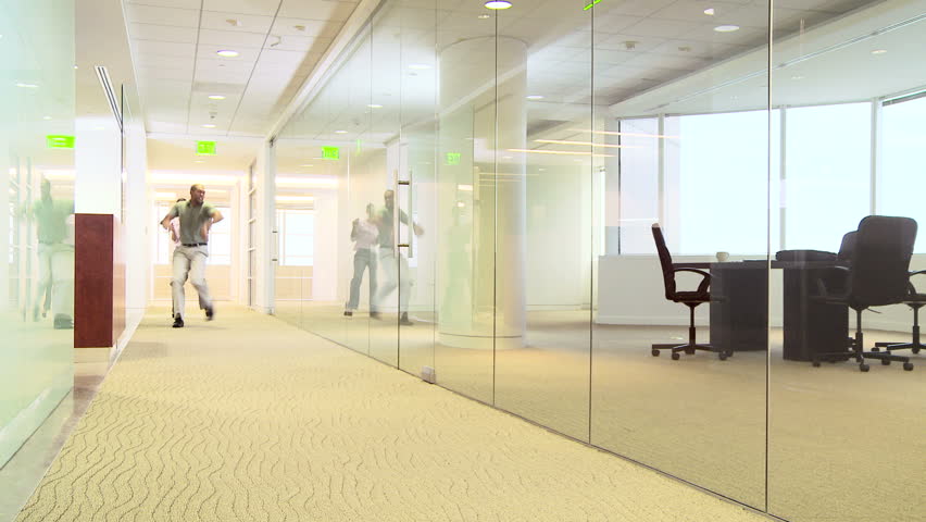 Group Of Business Professionals Walking Away Down Office Hallway Stock ...