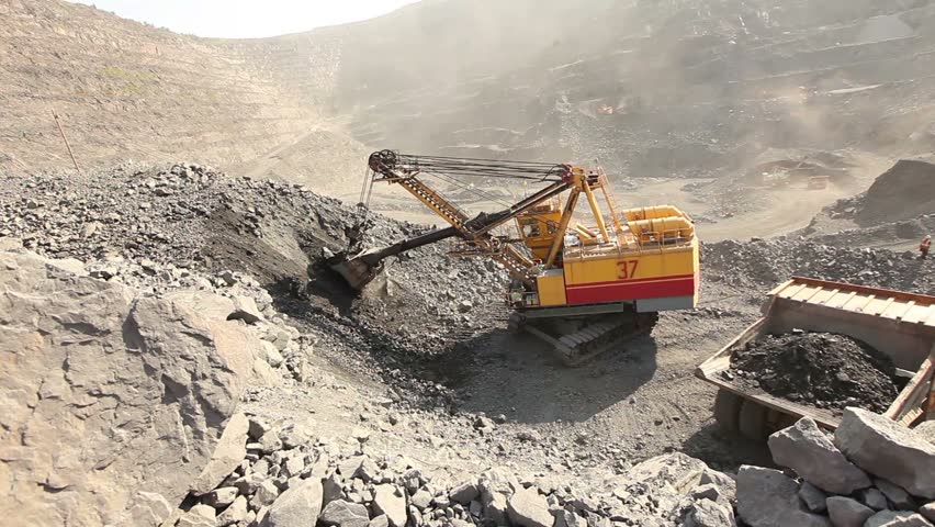 A Large Excavator Working In A Quarry, Ship Ore To The Big Yellow Truck ...