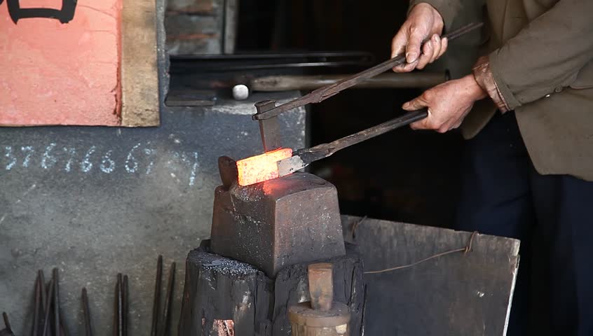 A Blacksmith In China Using Modern Machine To Forge The Iron To A Knife ...