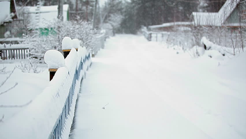 Стоковое видео на тему «Blizzard in Russian village. Fence under snow ...