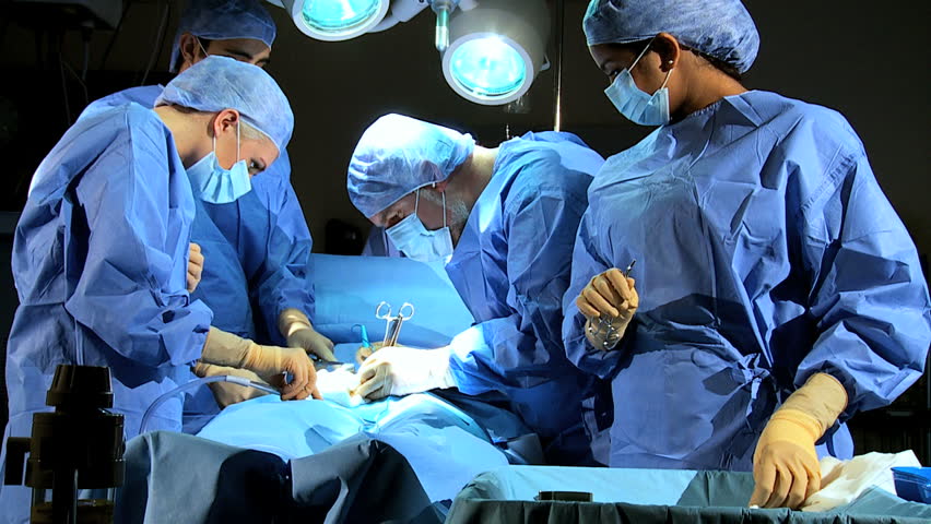 Senior Doctor Performing Operation Using Surgical Equipment Helped By ...