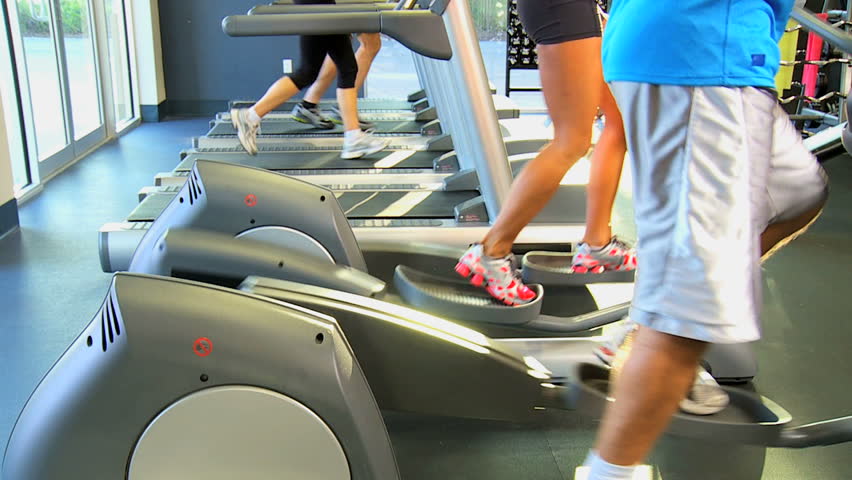 The Girl On A Bicycle In A Gym. Beautiful Girl In Red T-shirt Pedals In ...