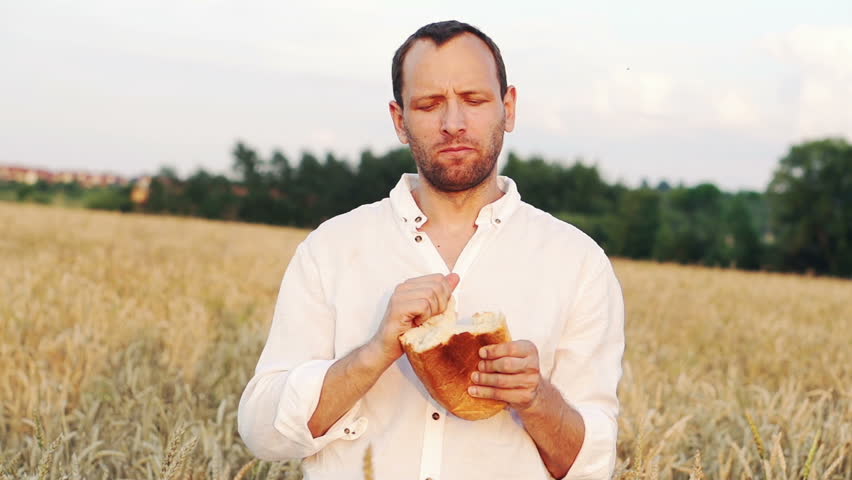 Stock video of man eating bread in wheat field, | 6989524 | Shutterstock