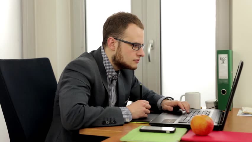 Young, Handsome Men Sitting Behind The Desk And In The Same Time He Is ...